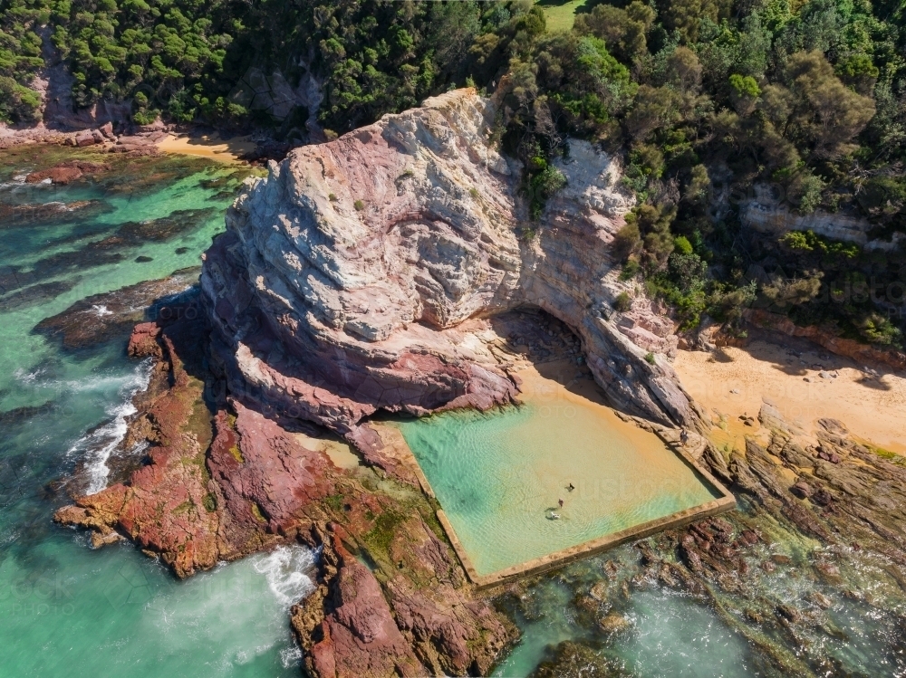 Image of Aerial view of a swimming rock pool alongside a beach and ...
