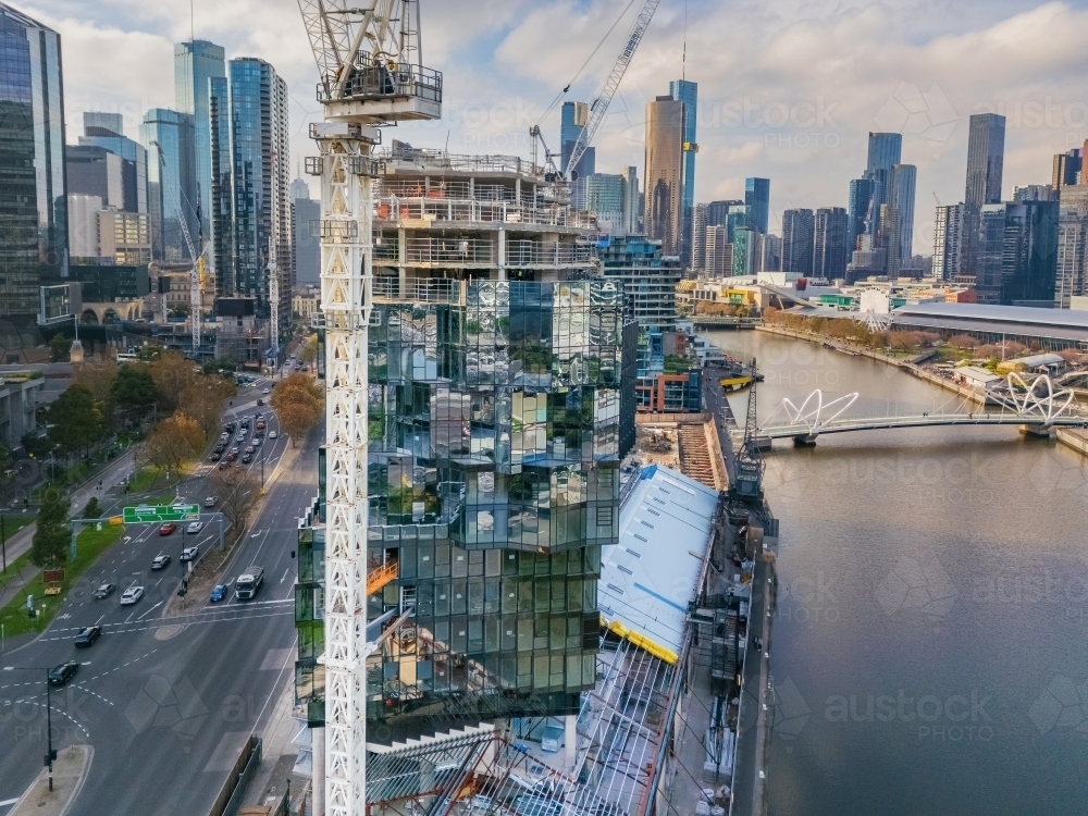 Image of Aerial view of a tall construction crane in front of a city ...