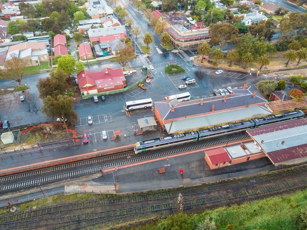 Image of Aerial view of a train and buses at a country railway station ...