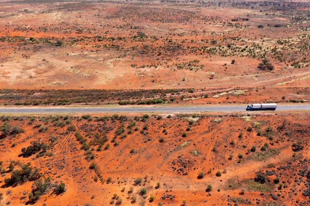 Image of Aerial view of a truck and trailer on a straight road through ...