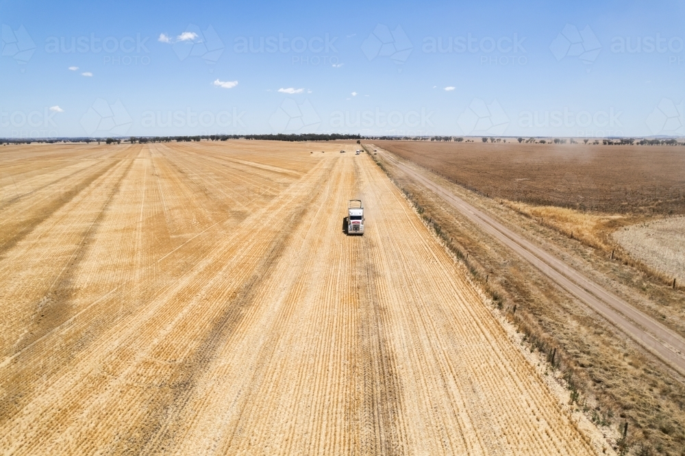 Image of Aerial view of a vast farmland with an open-top trailer truck ...