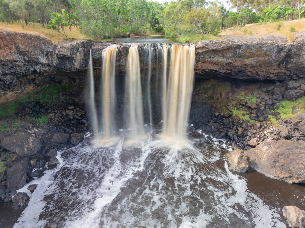 Image of Aerial view of a waterfall cascading over the edge of a rock ...