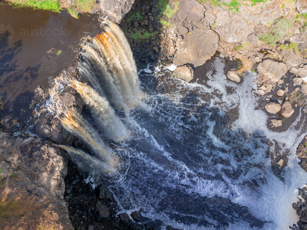 Image of Aerial view of a waterfall cascading over the edge of a rock ...
