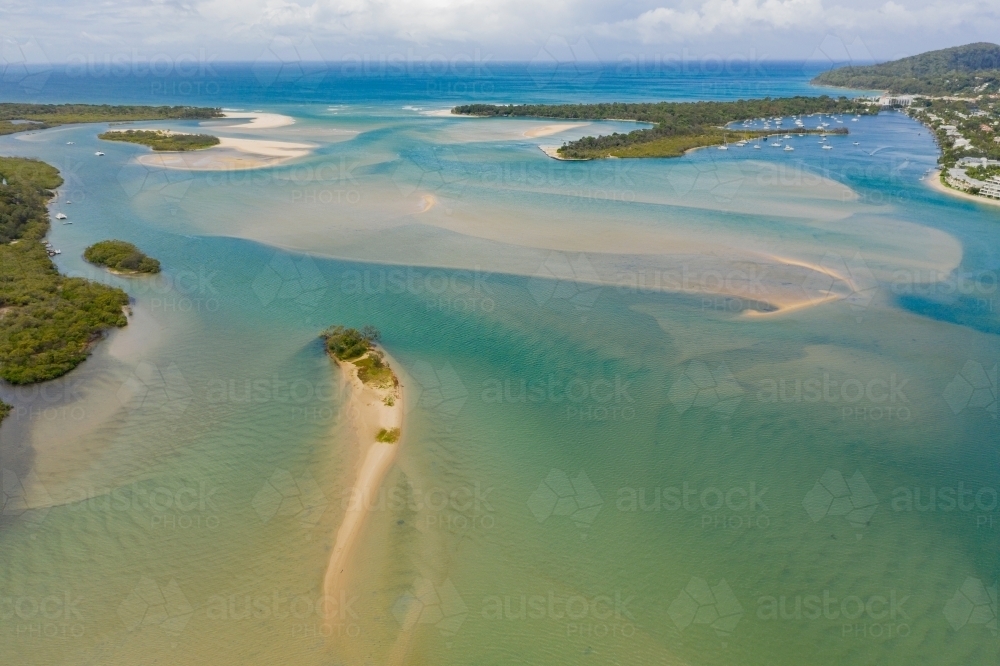 Image of Aerial view of a wide blue river flowing out to sea around ...