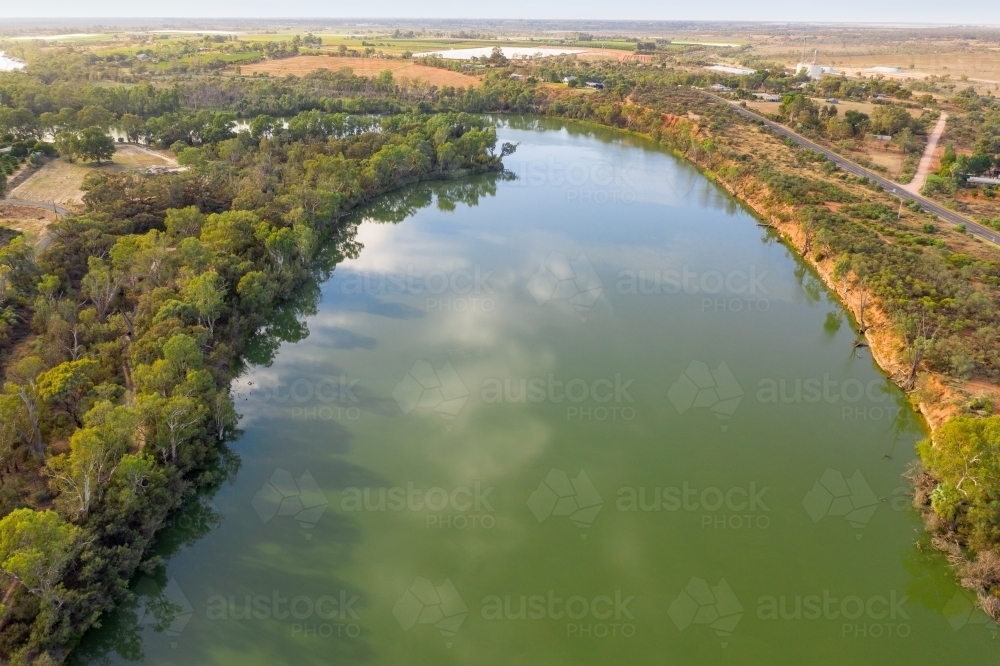 Image of Aerial view of a wide murky river with gum trees along the ...