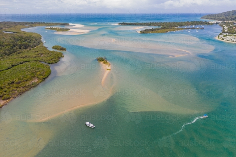 Image of Aerial view of a wide river flowing out to sea around islands ...