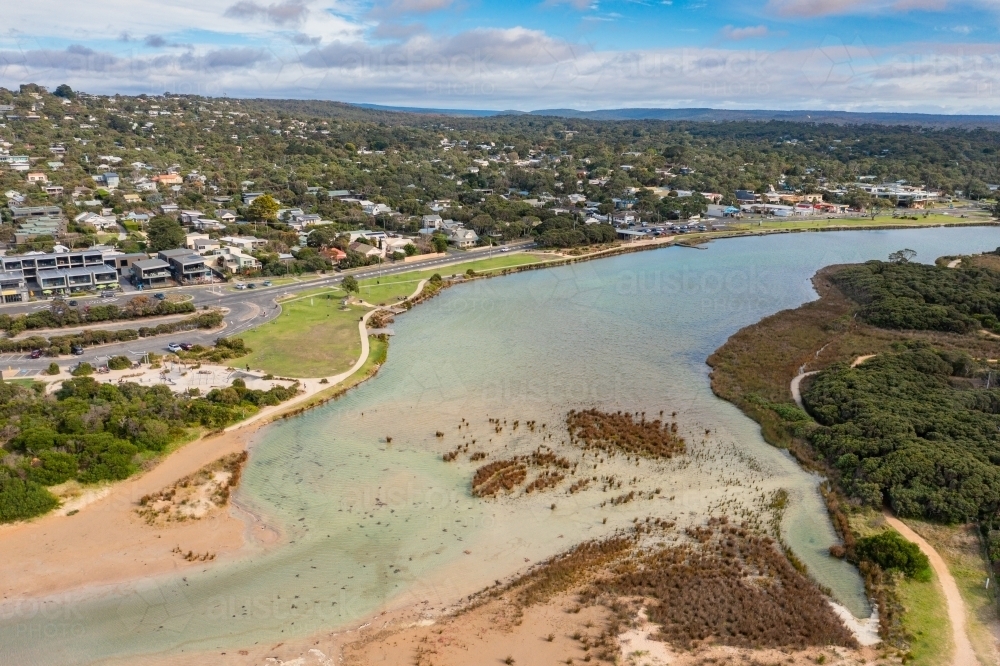 Image of Aerial view of a wide river flowing through a coastal town ...