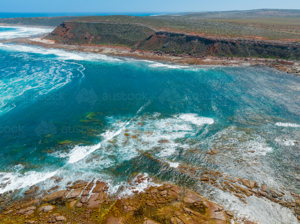 Image of Aerial view of a wide windswept bay of turquoise water between ...