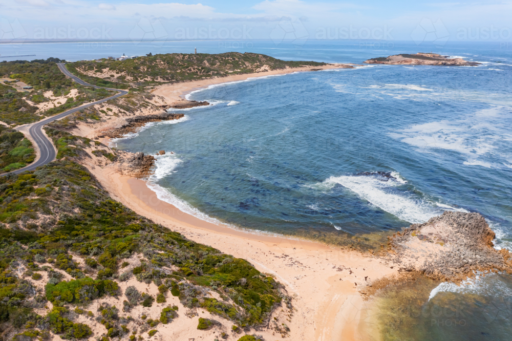 Image of Aerial view of a winding coastal road around curved sandy ...