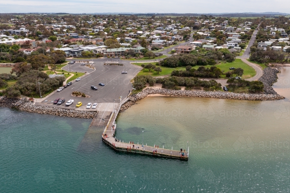Image of Aerial view of a wooden jetty next to a boat ramp in a coastal ...
