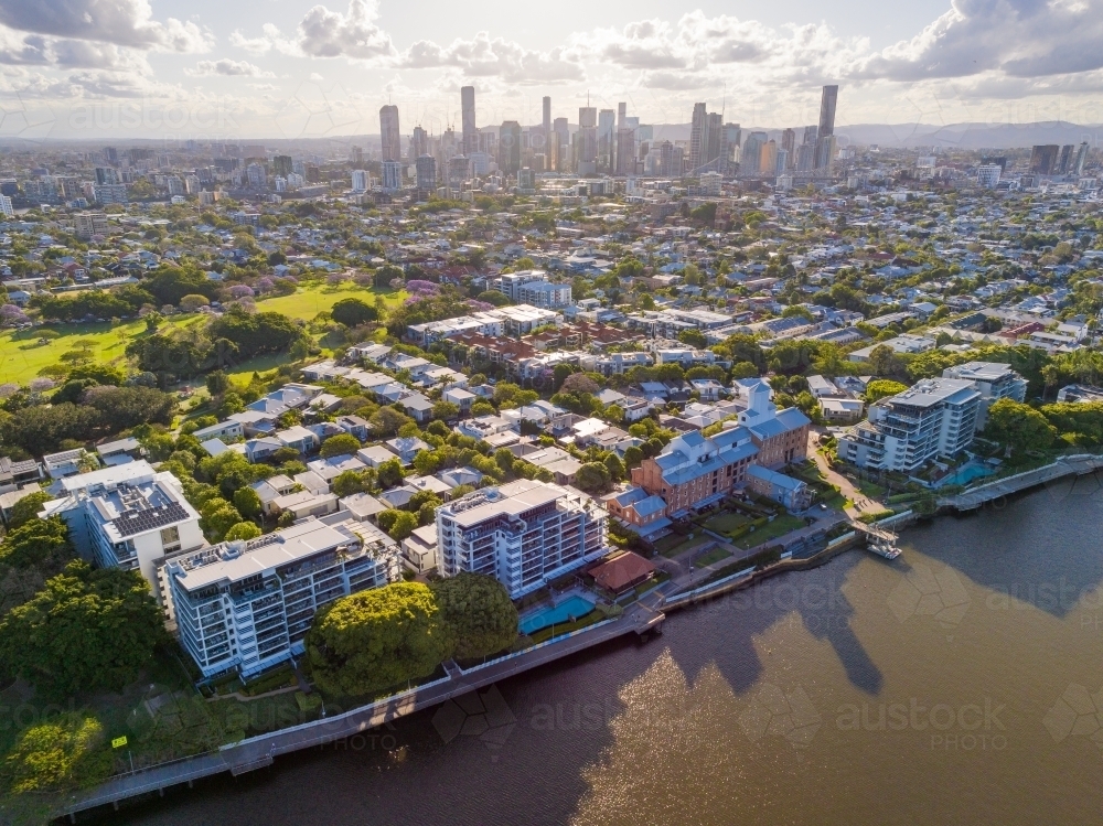 Image of Aerial view of apartment buildings on a river bank with a city ...