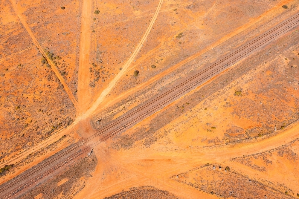 Image of aerial view of arid landscape with unsealed road crossing ...