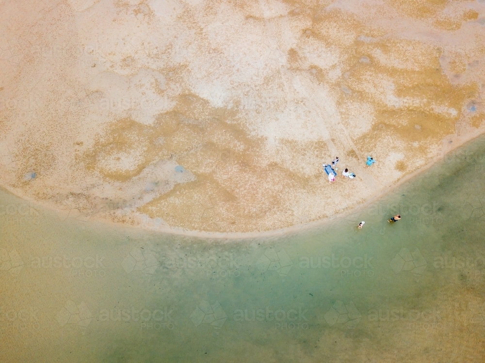 Image of Aerial view of beachgoers on a sand bank of a tidal estuary ...