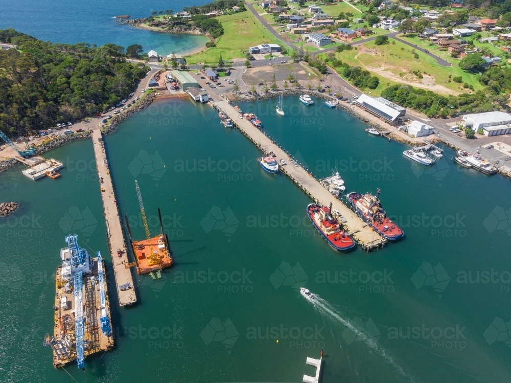 Image of Aerial view of boats and cranes alongside long piers in a ...
