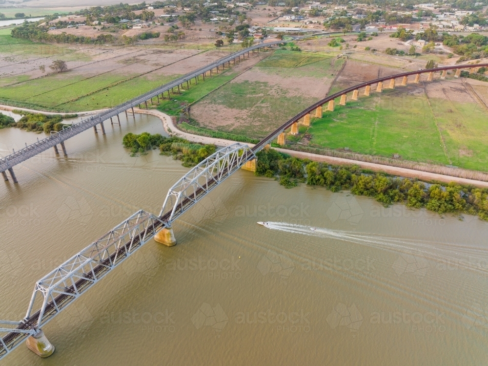 Image of Aerial view of bridges crossing a wide brown river alongside ...