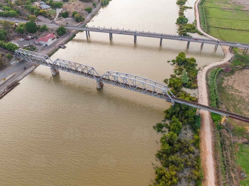 Image of Aerial view of bridges crossing a wide brown river - Austockphoto