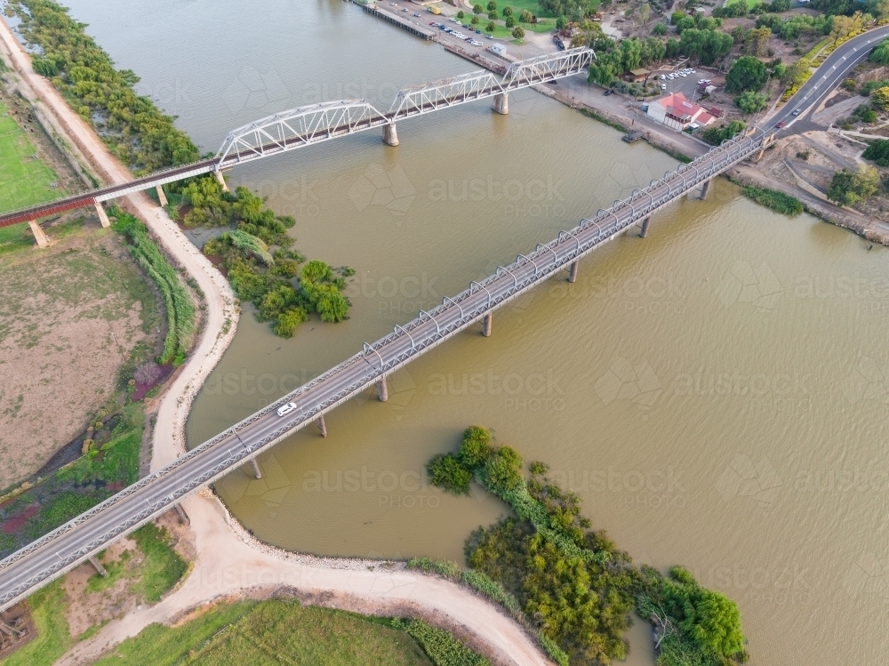 Image of Aerial view of bridges crossing a wide brown river - Austockphoto