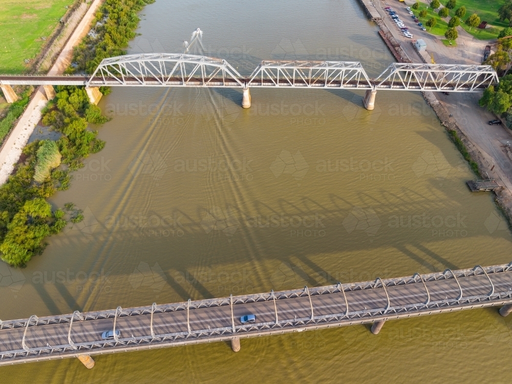 Image of Aerial view of bridges crossing a wide brown river - Austockphoto