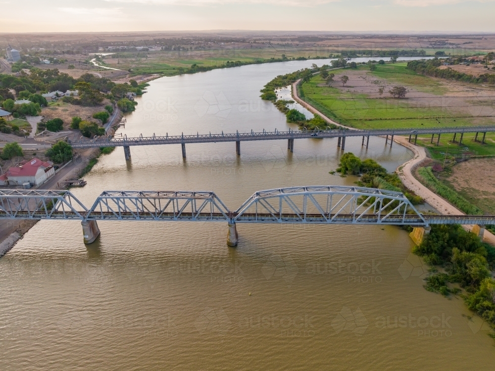 Image of Aerial view of bridges crossing a wide brown river - Austockphoto