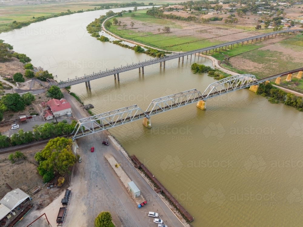Image of Aerial view of bridges crossing a wide brown river - Austockphoto