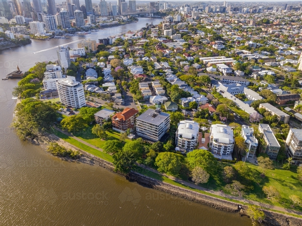Image of Aerial view of city buildings on both sides of a river bend ...