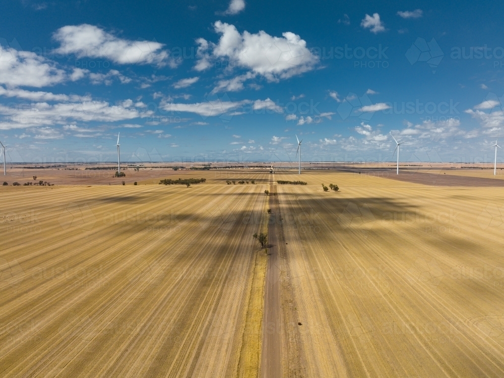 Image of Aerial view of cloud shadows and wind turbines in a ploughed ...