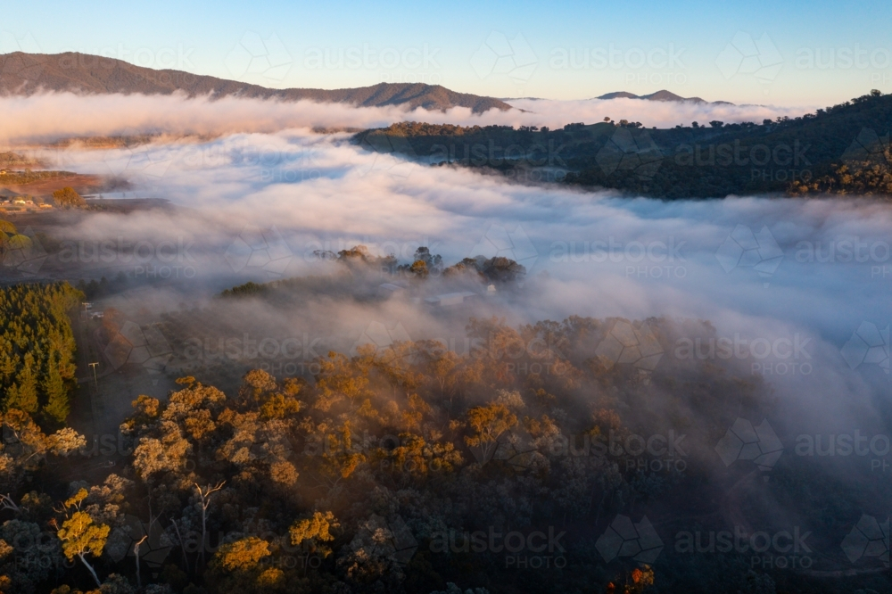 Image of Aerial view of clouds of fog over an inland lake and ...