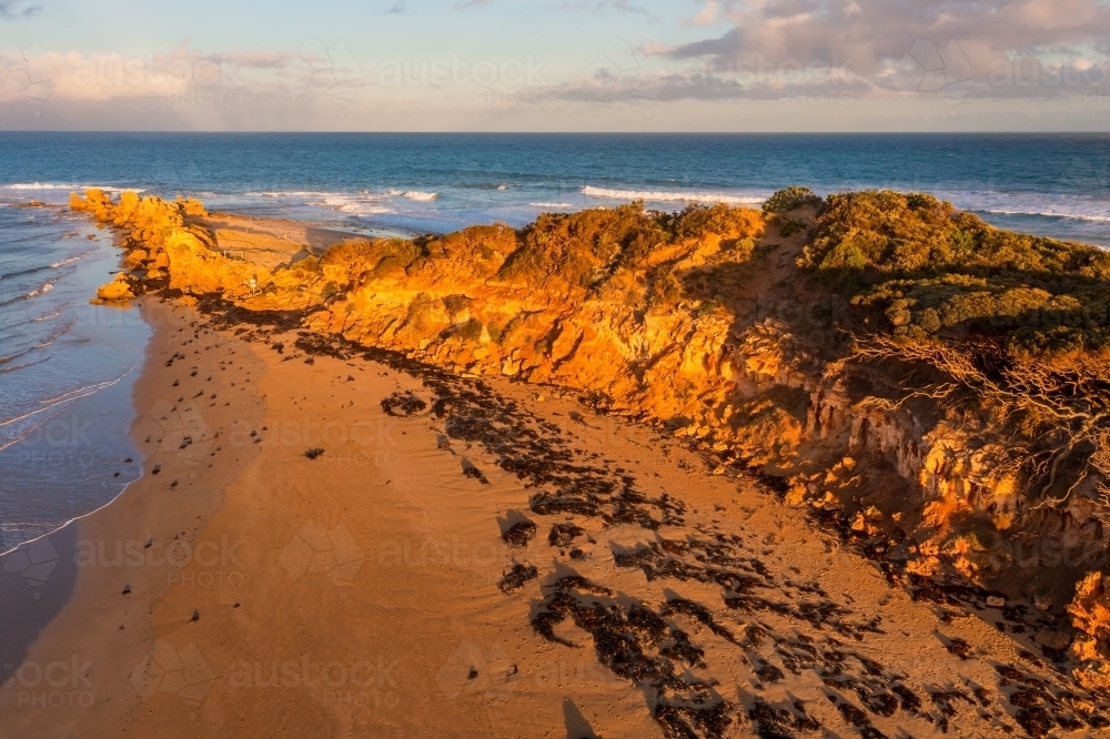 Image of Aerial view of coastal rock formations in golden lighting ...