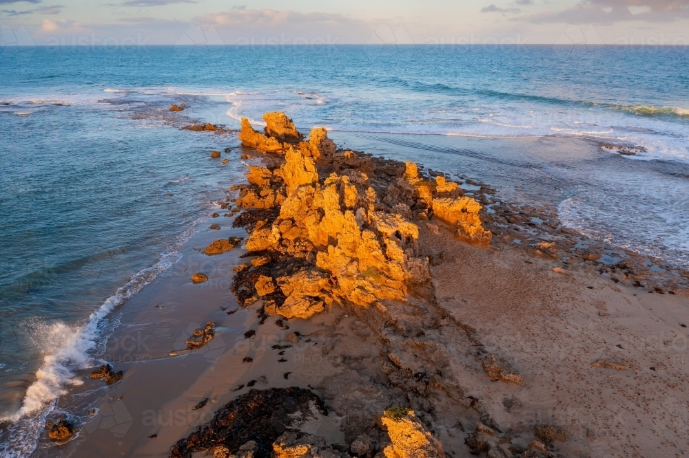 Image of Aerial view of coastal rock formations in golden lighting ...