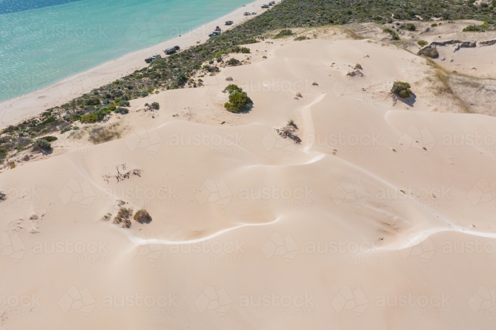 Image of Aerial view of coastal sand dunes next to a narrow beach and ...