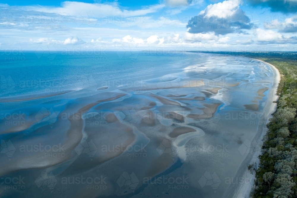 Image of Aerial view of coastline and sandbar patterns in shallow blue ...