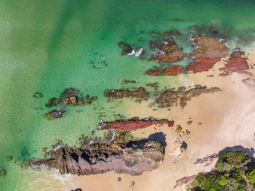 Image of Aerial view of coloured rocks around a rugged coastline ...