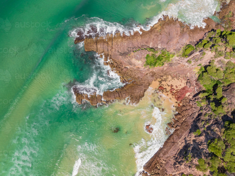 Image of Aerial view of coloured rocks around a rugged coastline ...