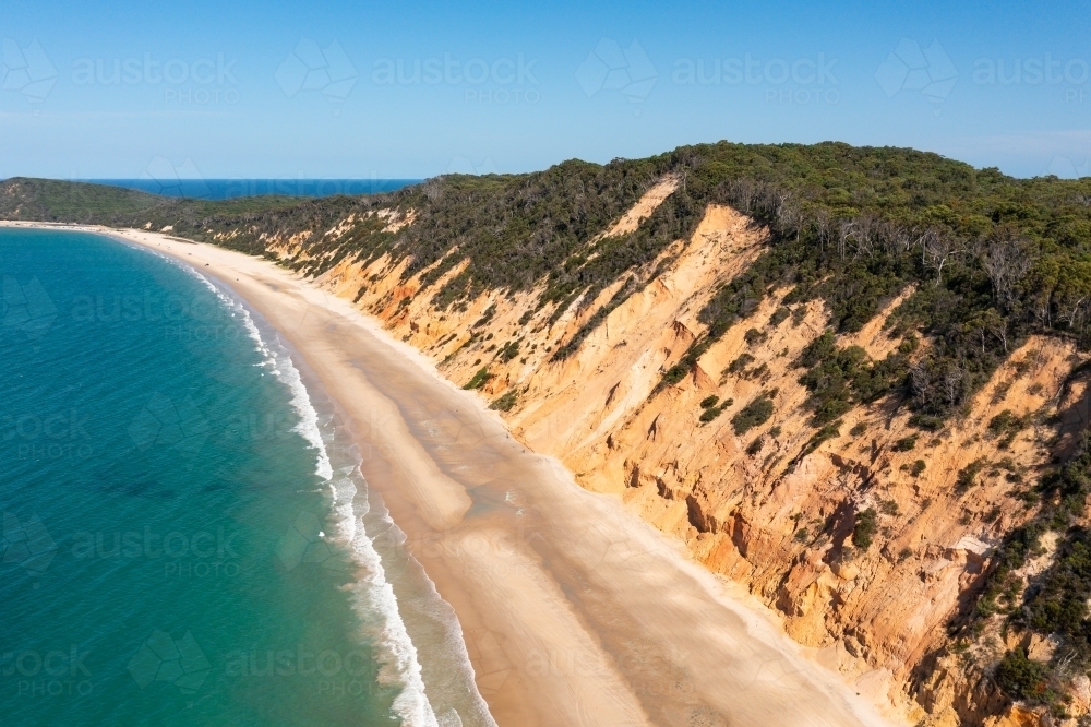 Image of Aerial view of coloured sandy cliffs above a beach and blue ...