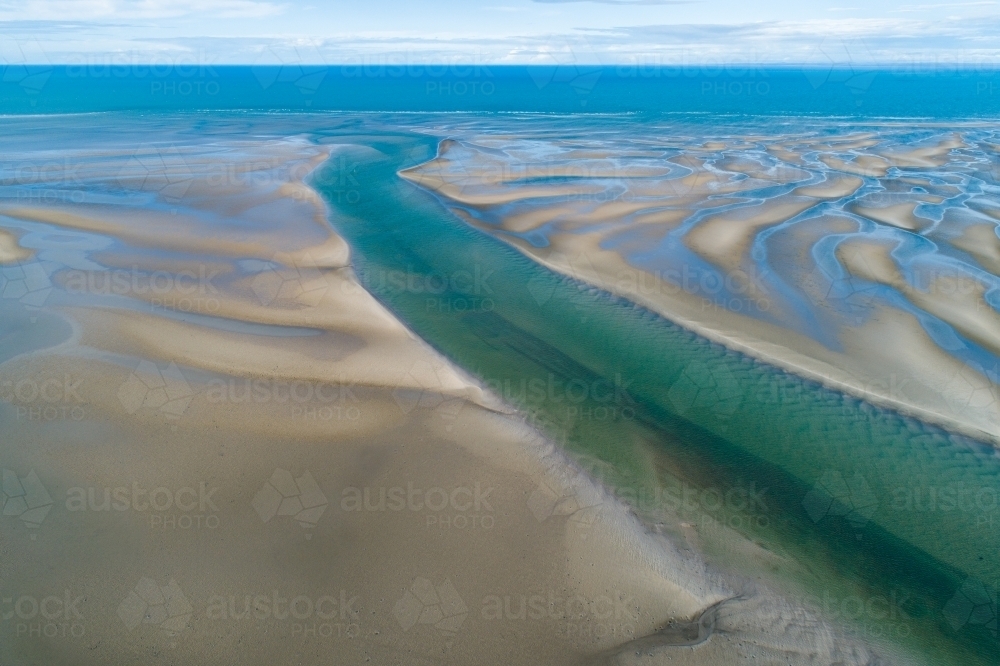 Image of Aerial view of creek and sandbar patterns in shallow blue ...