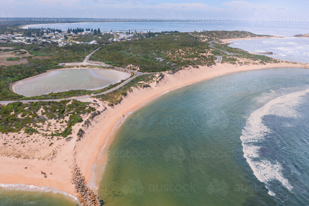 Image of Aerial view of curved sandy beaches in front of a coastal salt ...