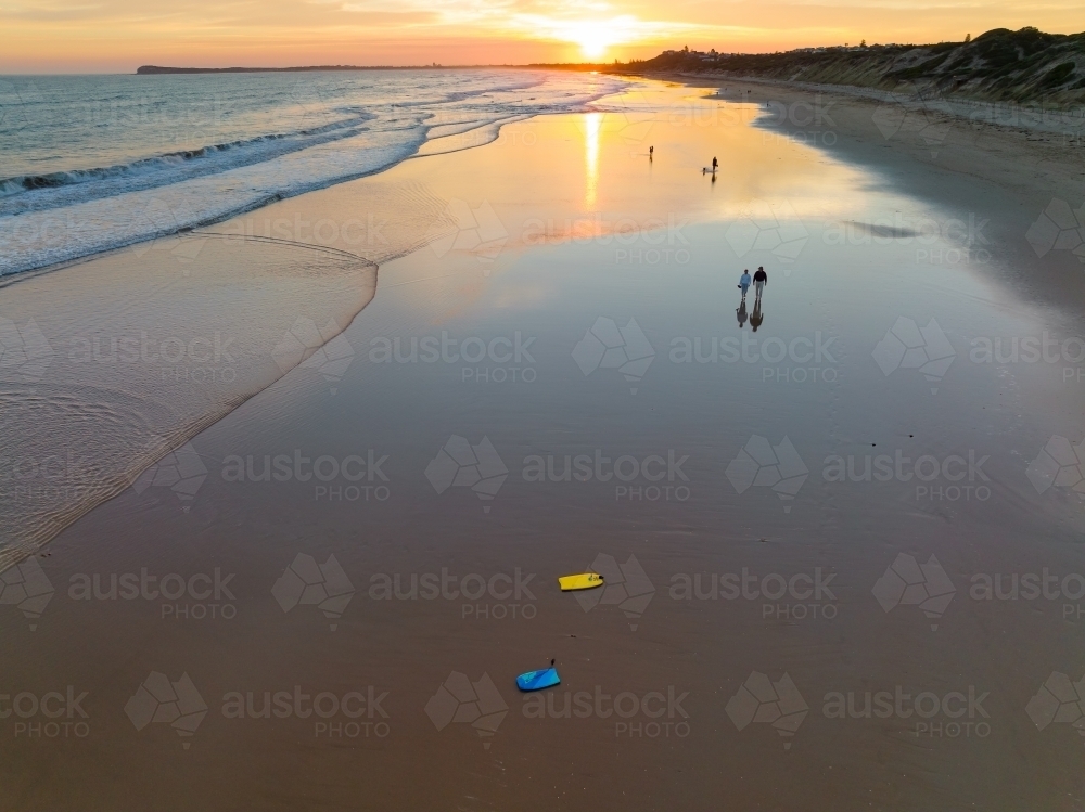 Image of Aerial view of deserted boogie boards and people walking on a ...