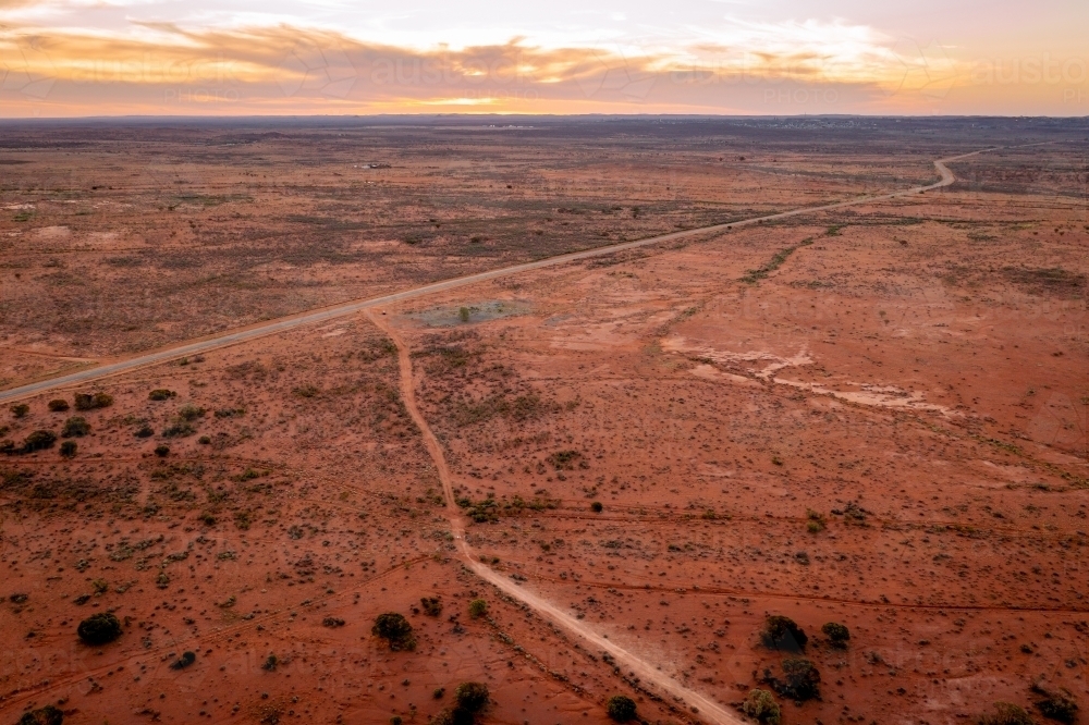 Image of Aerial view of dirt track over a barren outback landscape at ...
