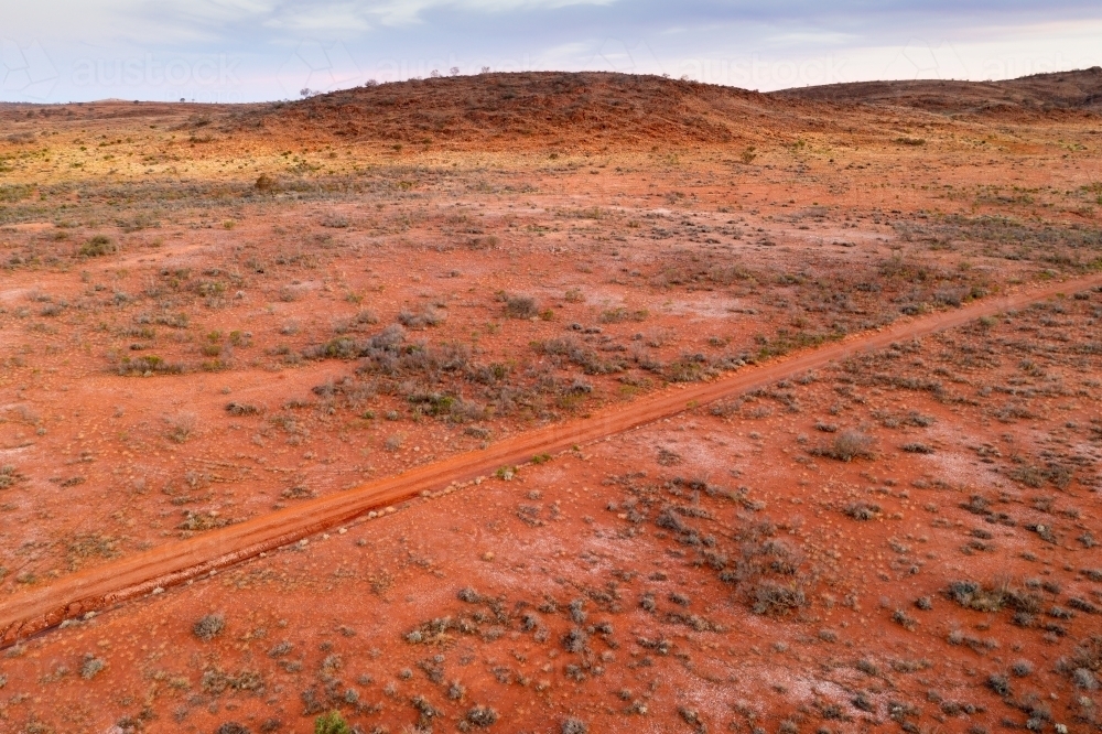 Image of Aerial view of dirt tracks through a red outback landscape at ...