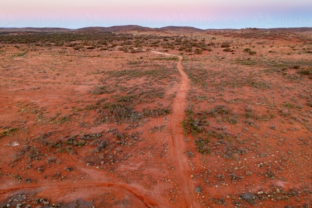 Image of Aerial view of dirt tracks through a red outback landscape at ...