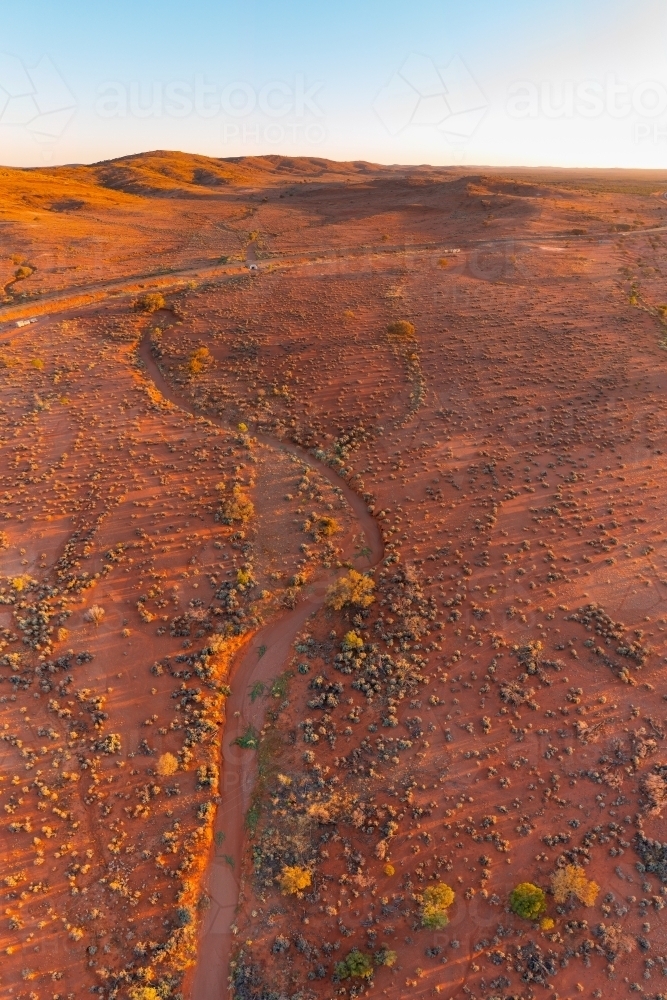 Image of Aerial view of dirt tracks through a red outback landscape at ...