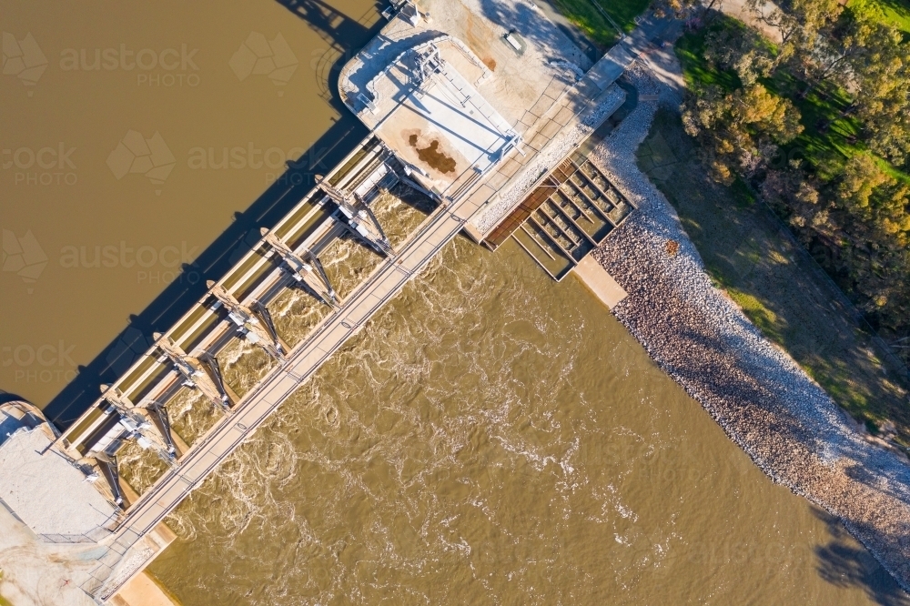 Image of Aerial view of dirty river water rushing through the gates of ...