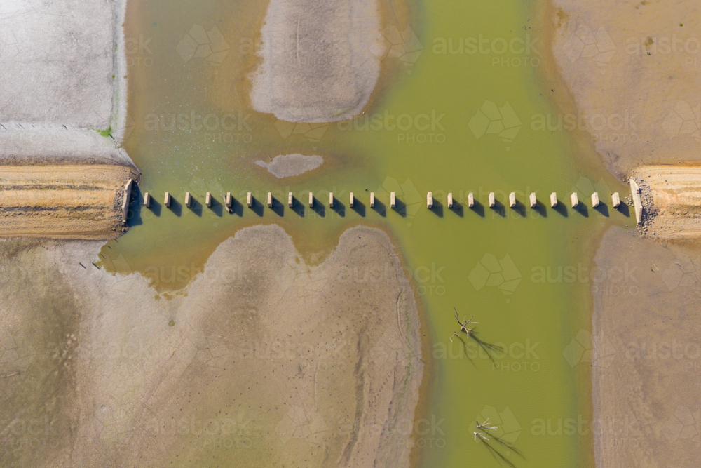 Image of Aerial view of disused bridge pylons crossing mud flats and ...