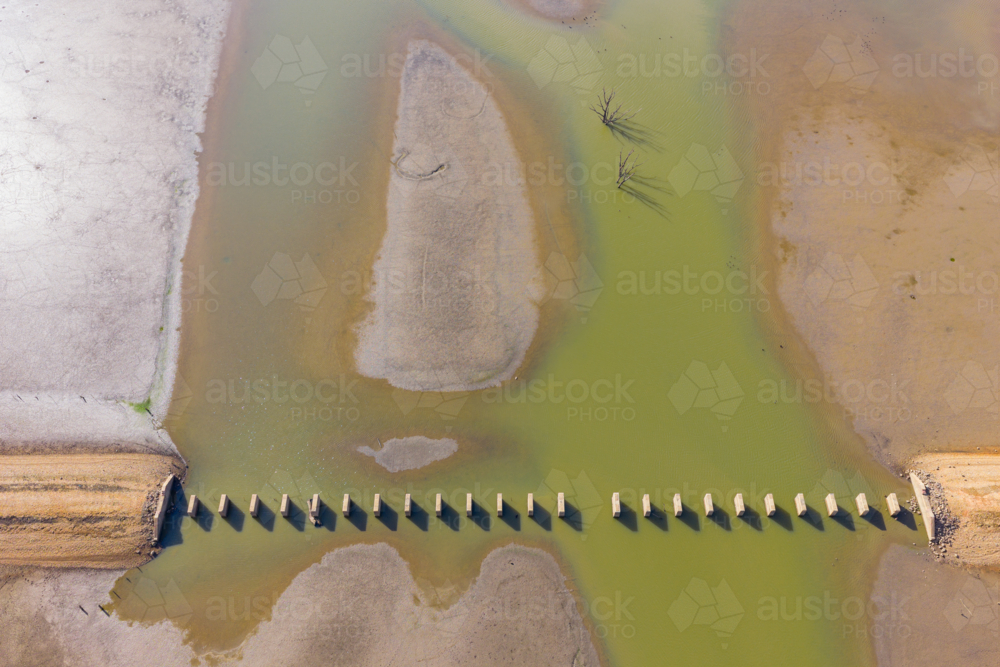 Image of Aerial view of disused bridge pylons crossing mud flats and ...