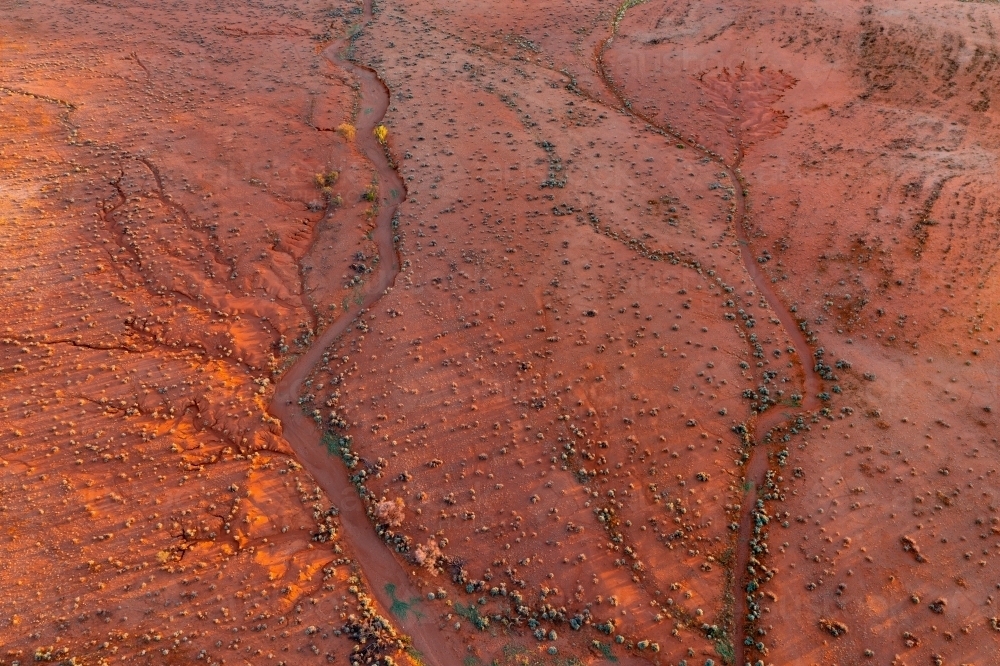 Image of Aerial view of dry creek beds running through a barren orange ...