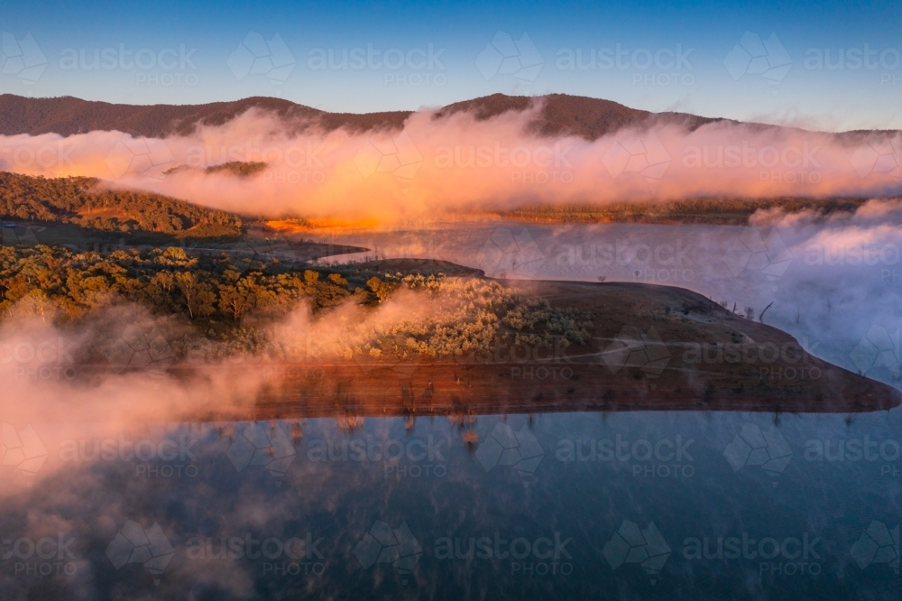 Image of Aerial view of early morning light on clouds of fog over an ...