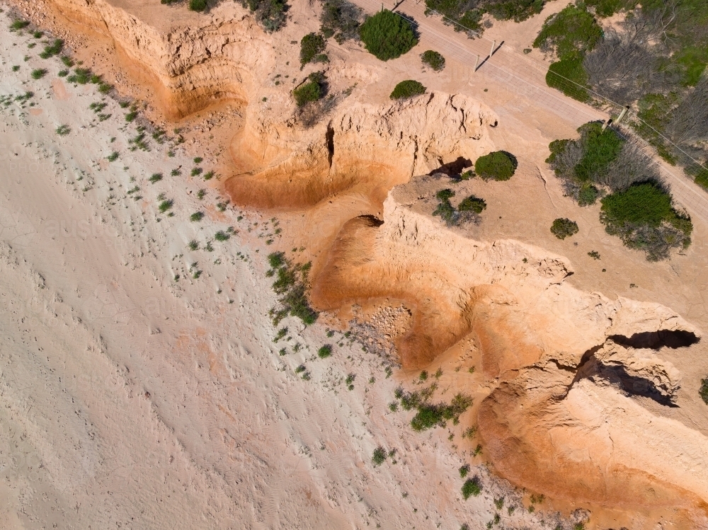 Image of Aerial view of eroded cliffs and gullies above a sandy beach ...