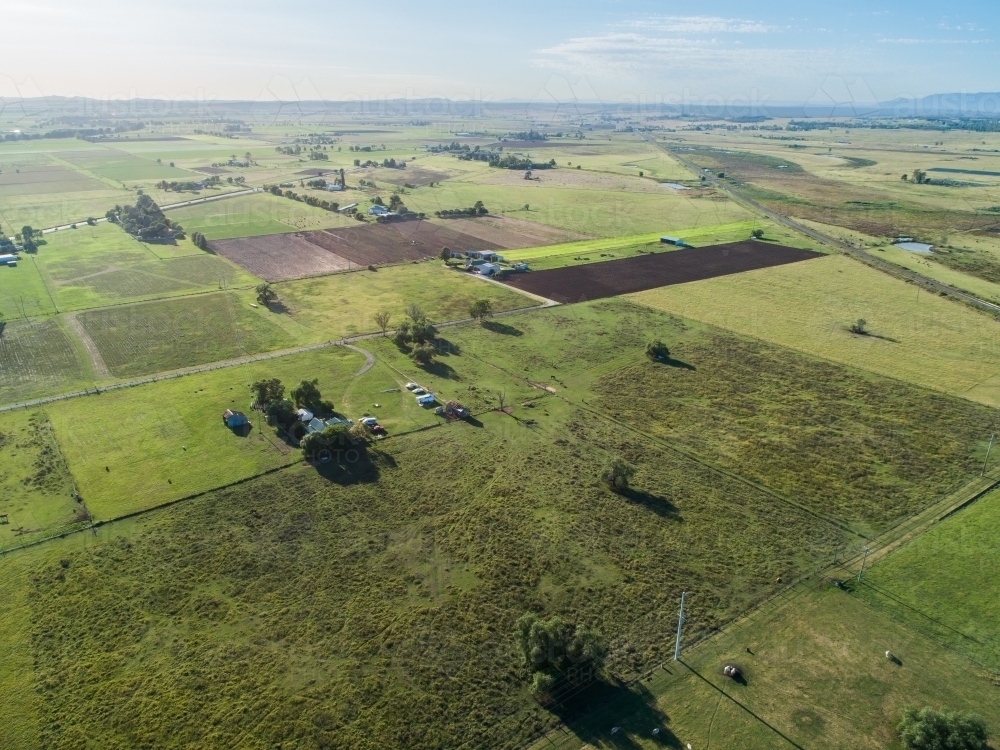 Image of aerial view of farm paddocks at the edge of town with train ...
