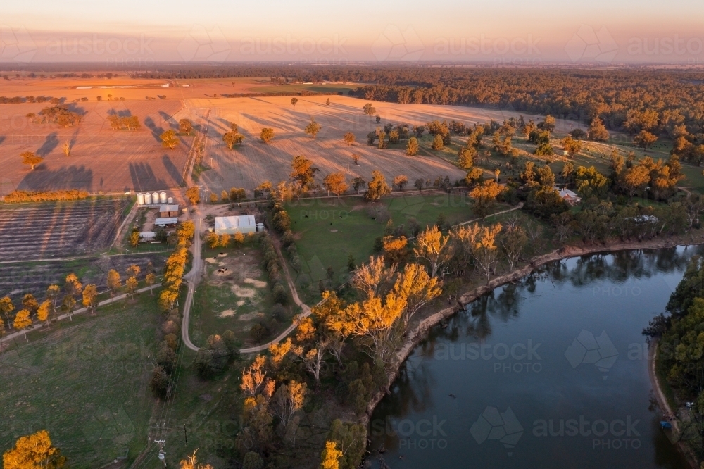 Image of Aerial view of farmland alongside a river in early morning ...