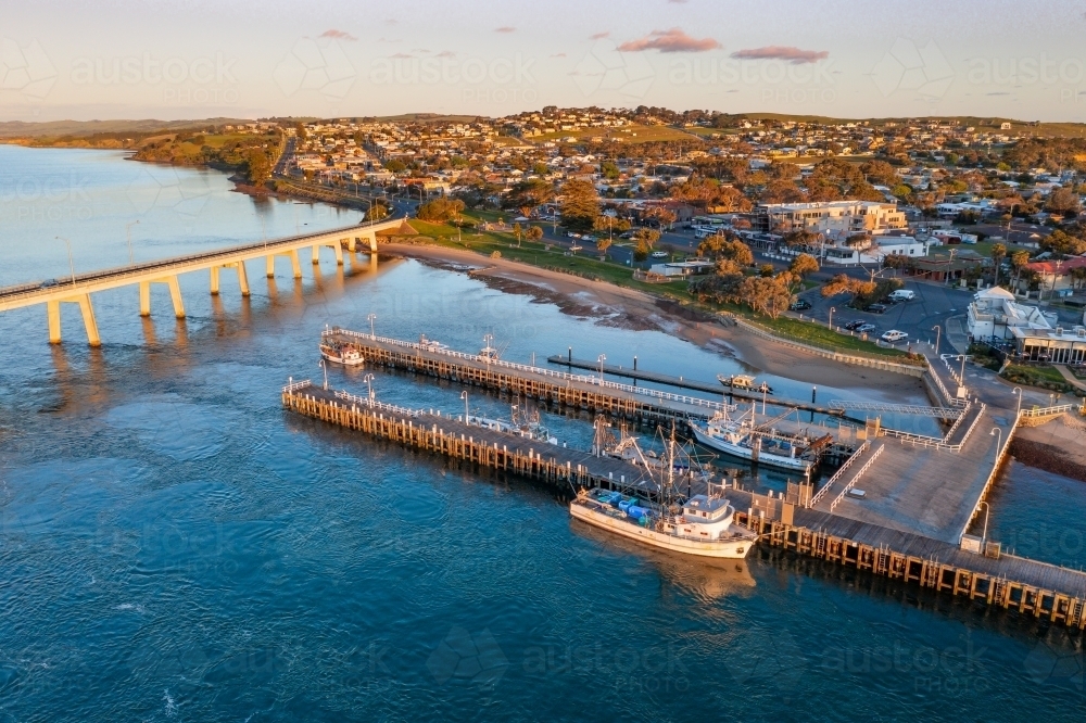 Image of Aerial view of fishing boats docked alongside jetties near a ...